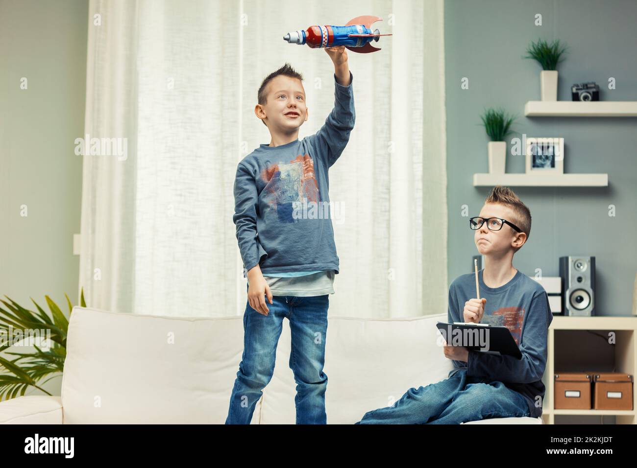 Two boys playing together at home with toy rocket and tablet Stock ...