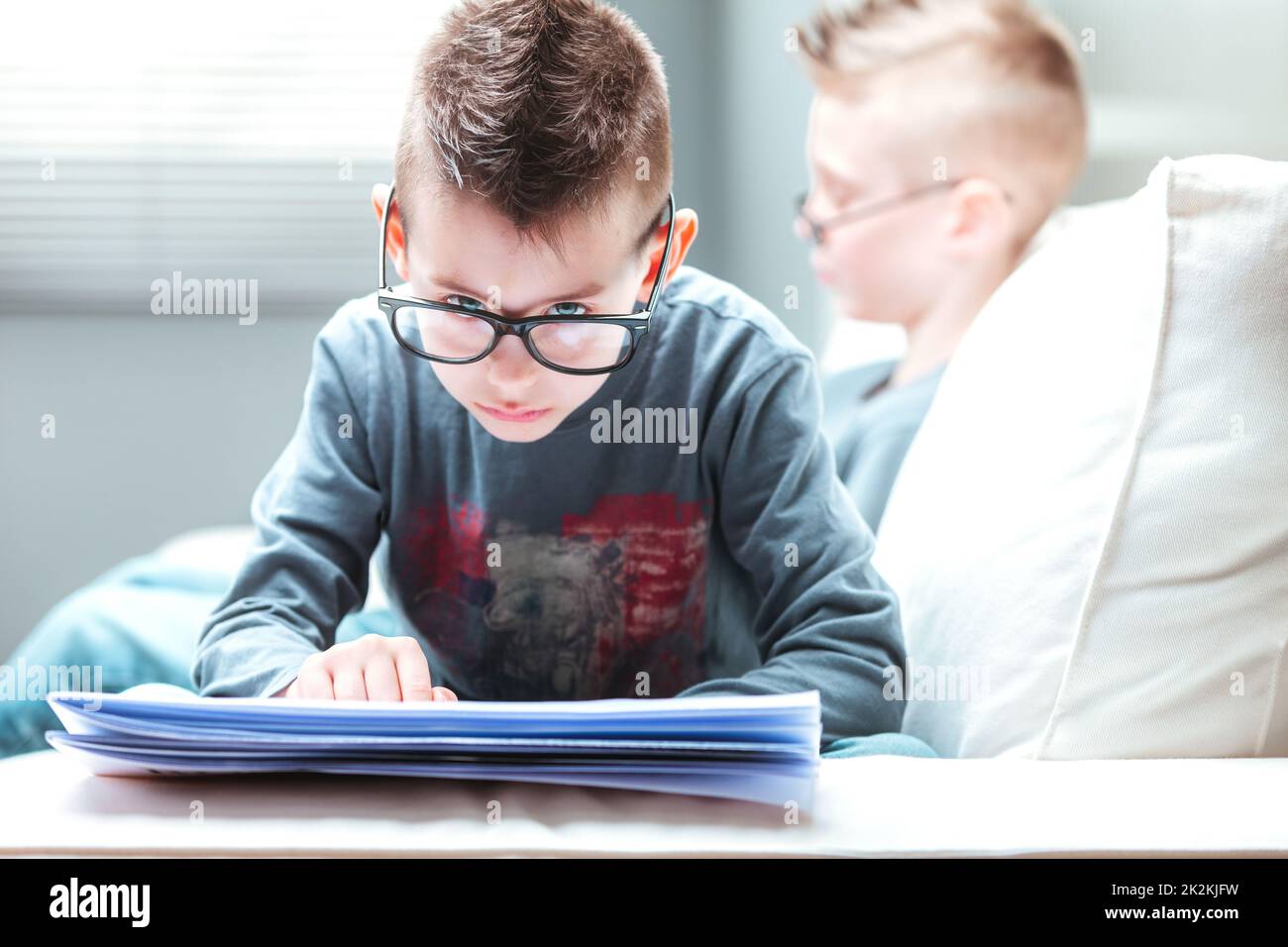 Young blue-eyed boy with upswept hairstyle relaxing reading Stock Photo ...
