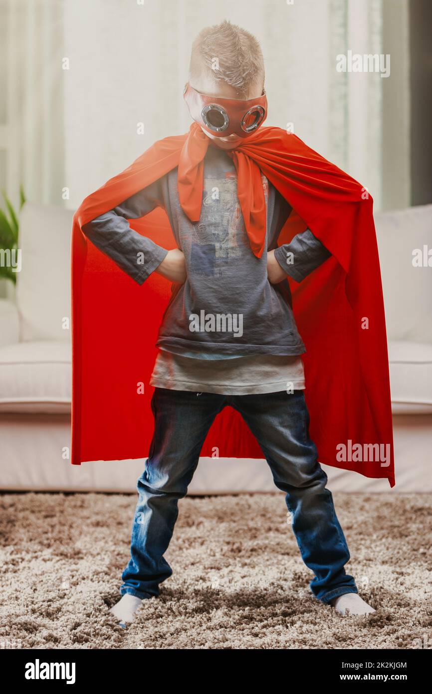 Young boy posing arms akimbo in a super hero costume Stock Photo - Alamy