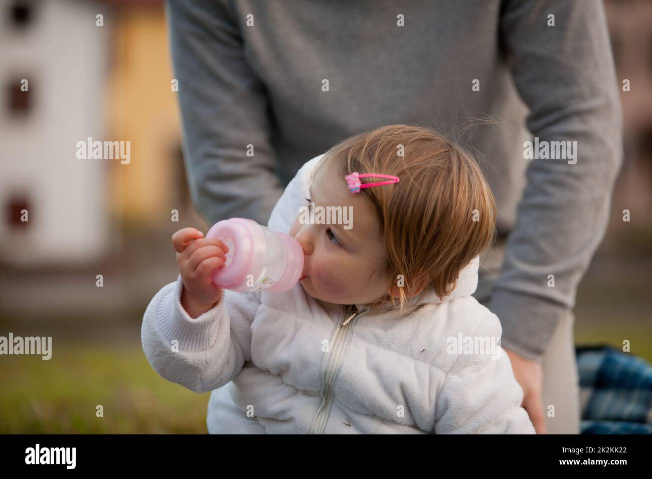 little daughter sucking from her feeding bottle Stock Photo - Alamy