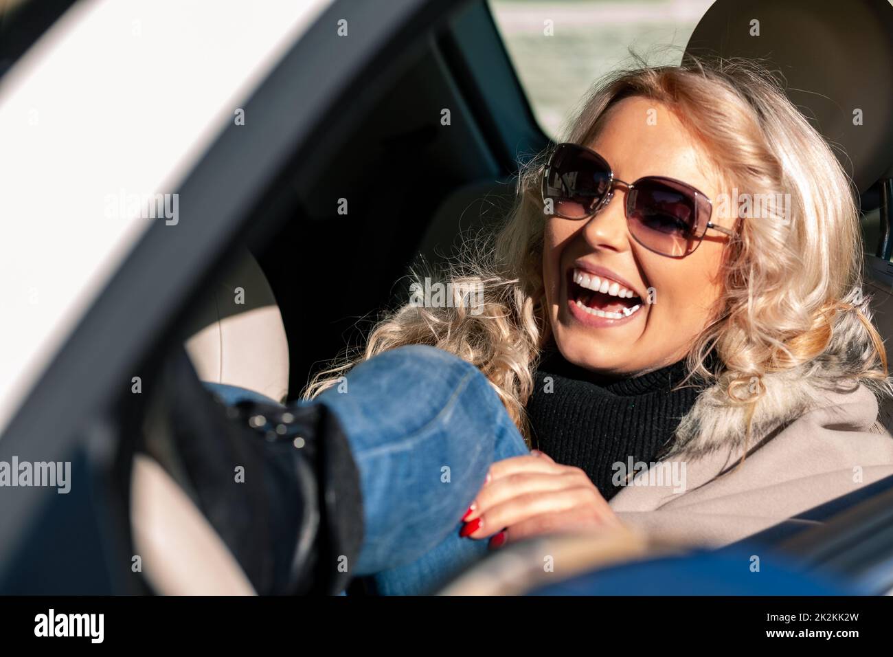 Laughing playful young woman with her feet up Stock Photo - Alamy