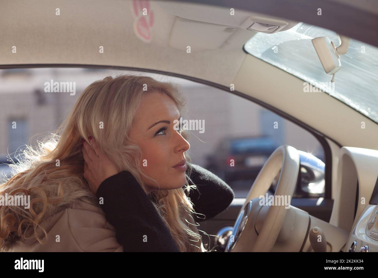 Dangerous young woman driver fluffing up her hair Stock Photo - Alamy
