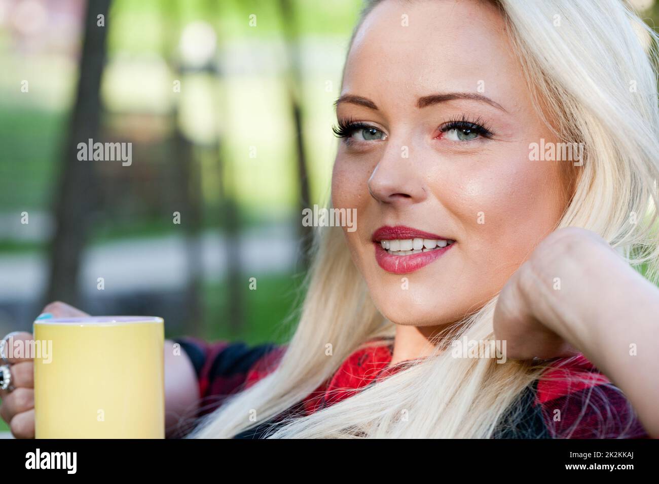 pretty woman drinking from a mug in the nature Stock Photo - Alamy