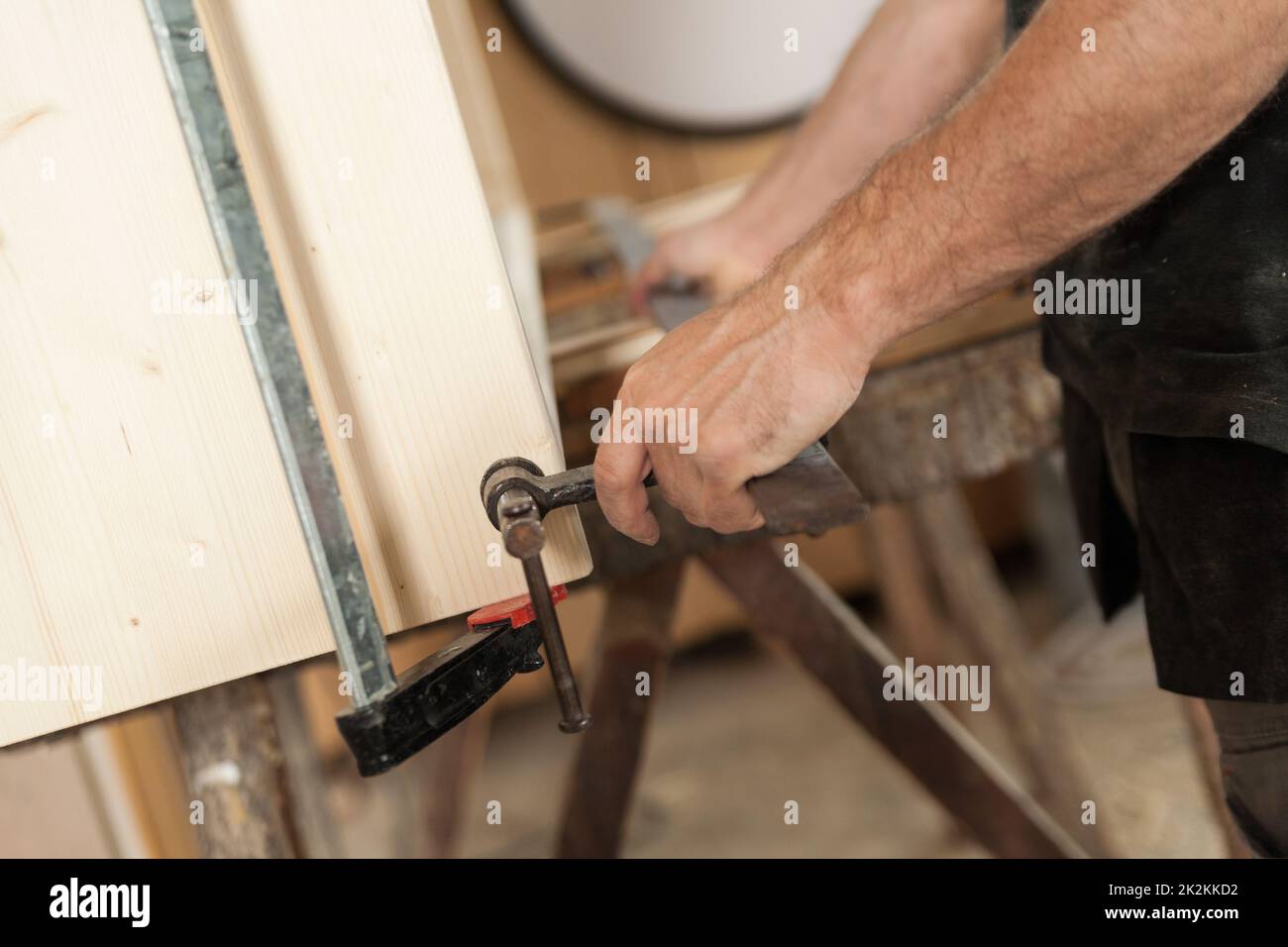 hand clamping a wooden board or piece of furniture Stock Photo - Alamy