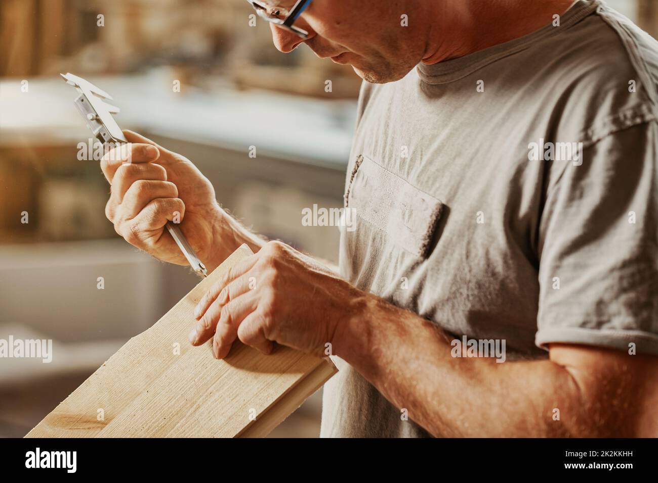 Carpenter taking a measurement of a plank of wood with calliper Stock ...