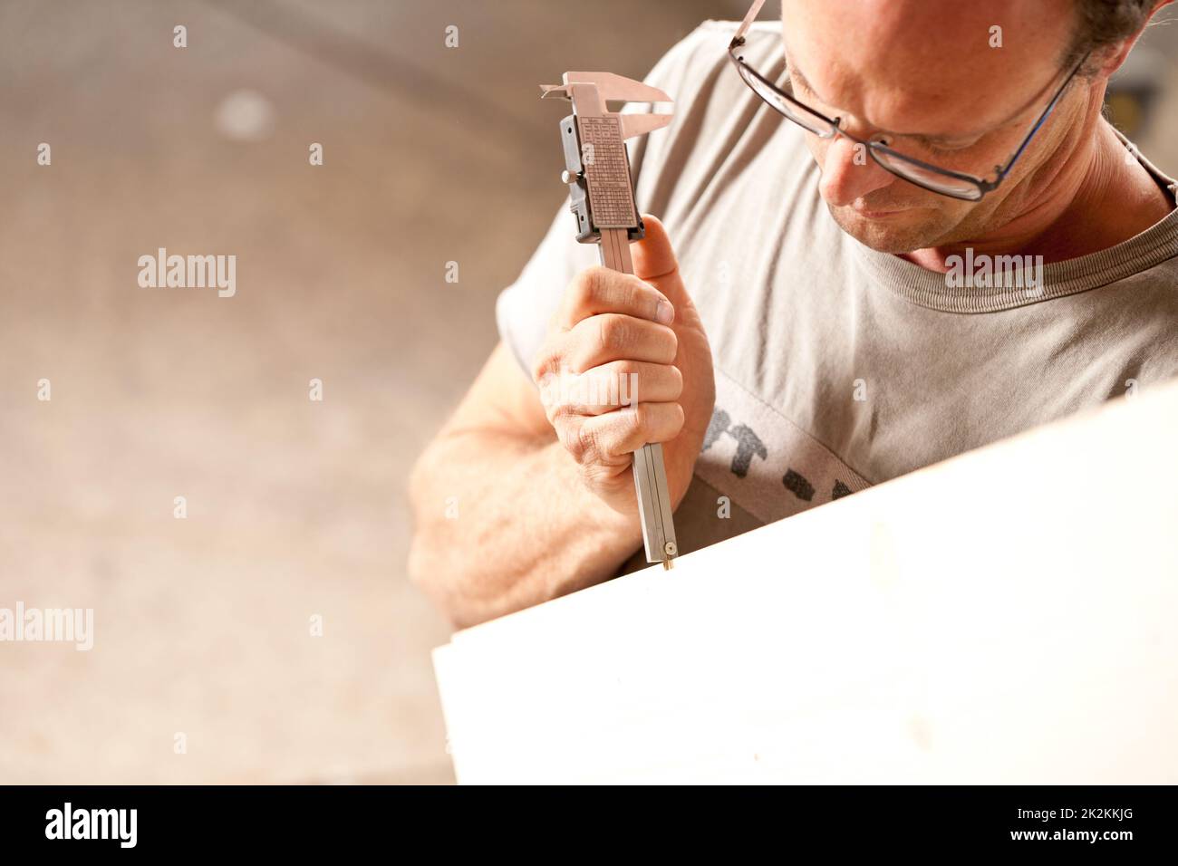 carpenter measuring a board with calipers Stock Photo - Alamy