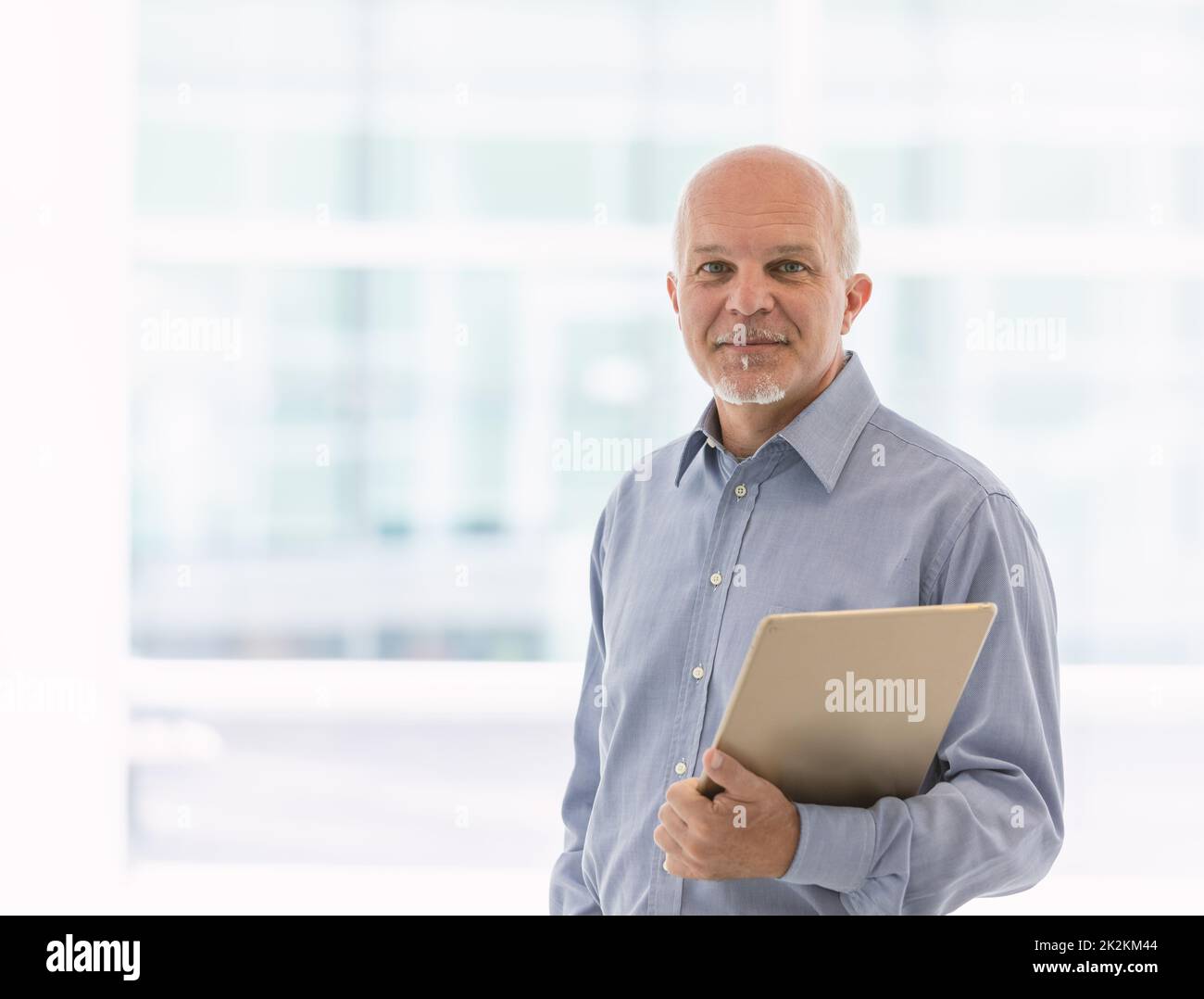man holding tablet in one arm Stock Photo - Alamy