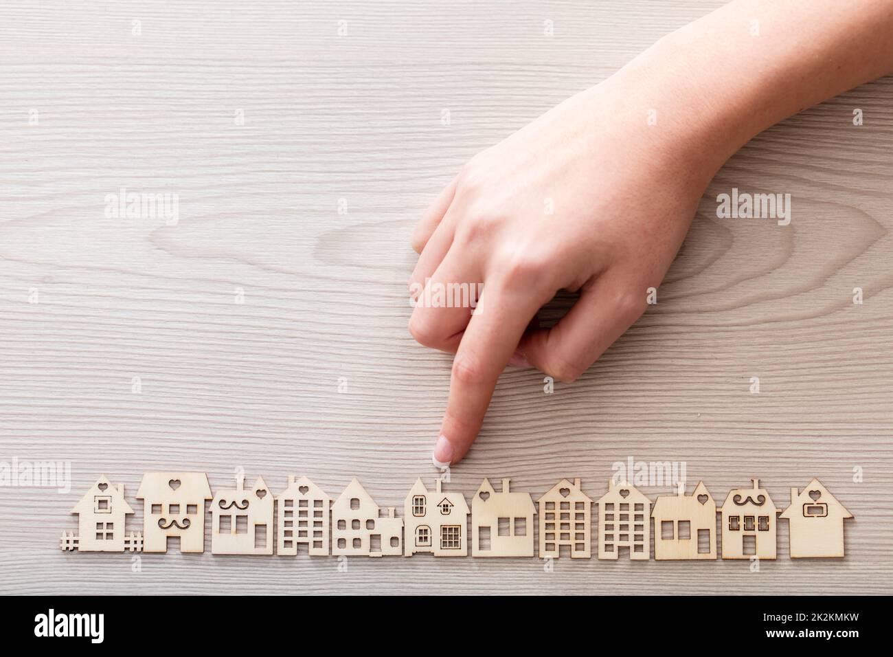 hand pointing out a house among the others mini figures in a micro ...