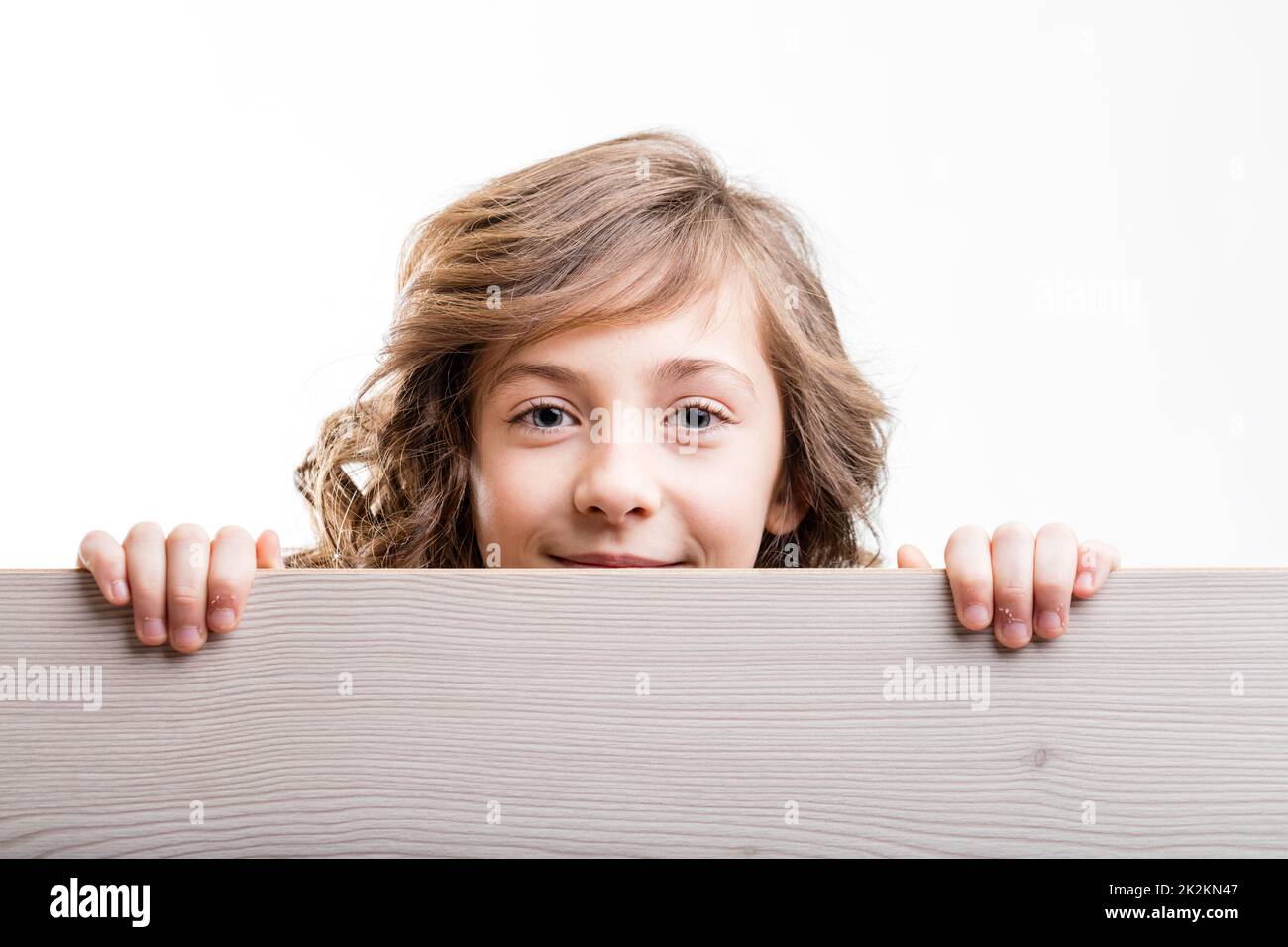 little girl looks from behind a board Stock Photo - Alamy
