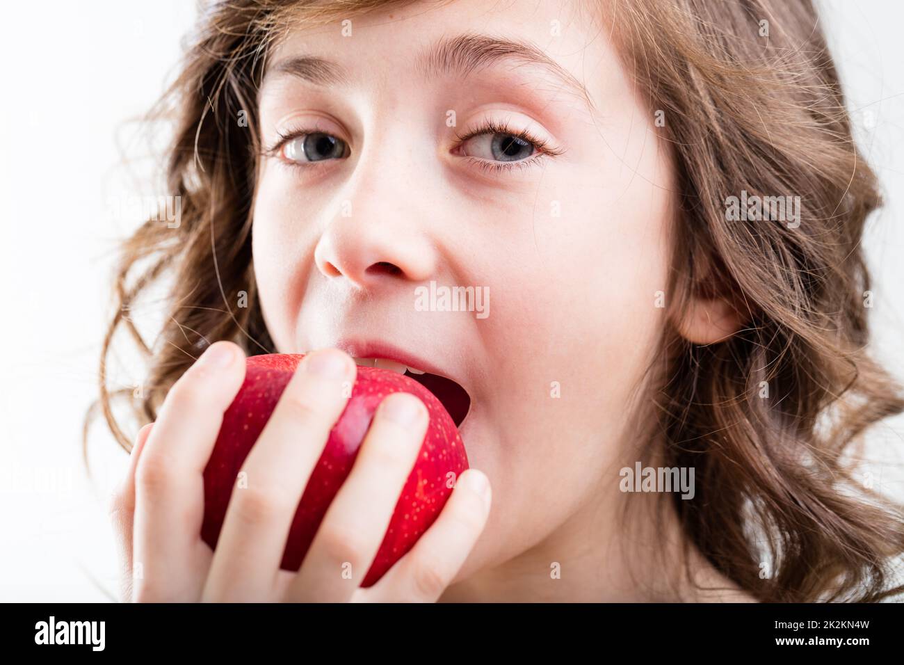 girl eats red apple on white background Stock Photo - Alamy