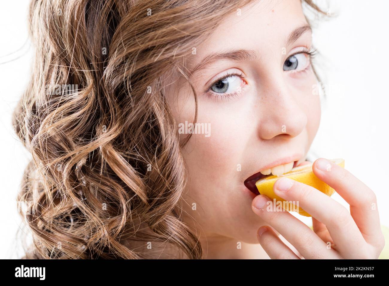girl enjoying sour taste of lemon Stock Photo - Alamy