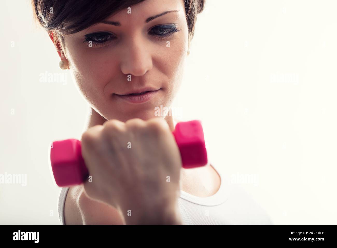 Young woman working out with weights concentrating on a routine Stock ...