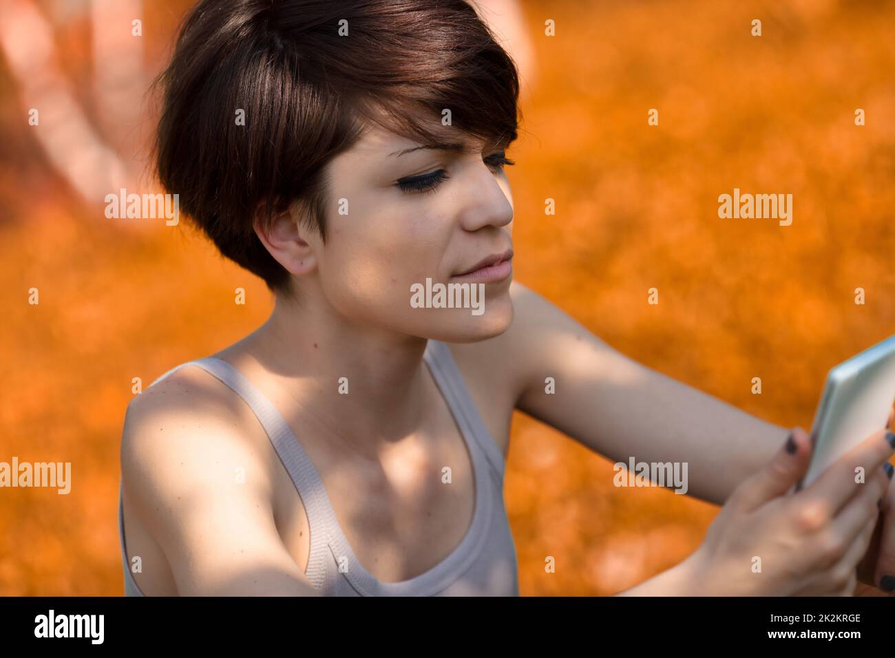 Young woman reading a text message on her mobile phone Stock Photo - Alamy
