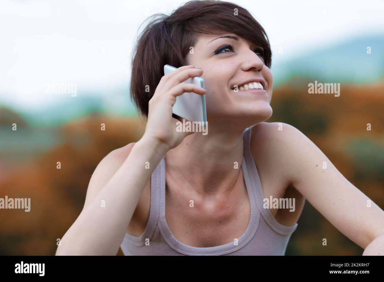 Happy vivacious woman chatting on her mobile phone Stock Photo - Alamy