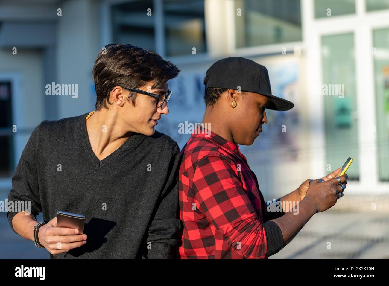 Young man reading a friends phone messages over his shoulder Stock ...
