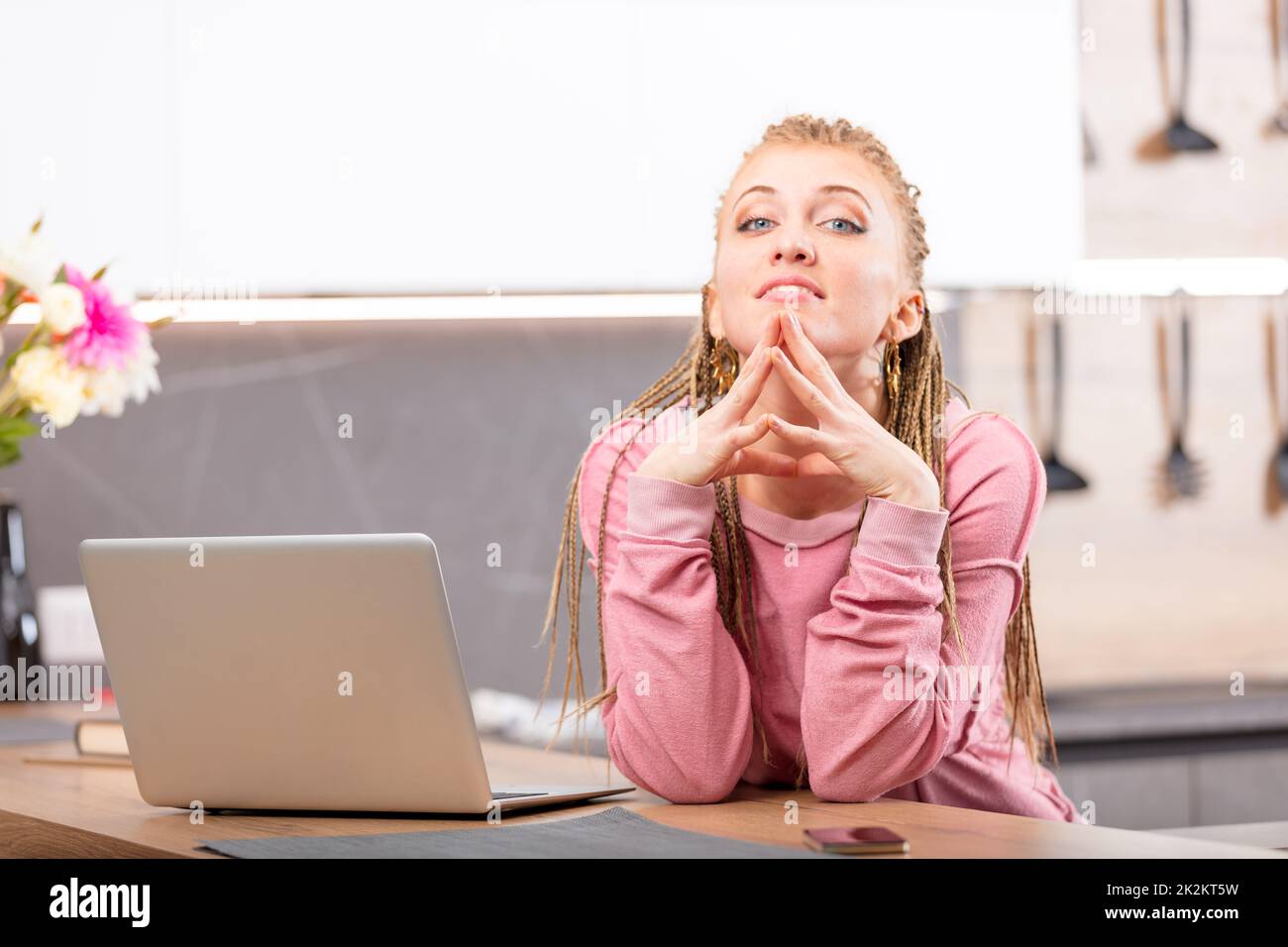 Young woman sitting next to computer Stock Photo - Alamy
