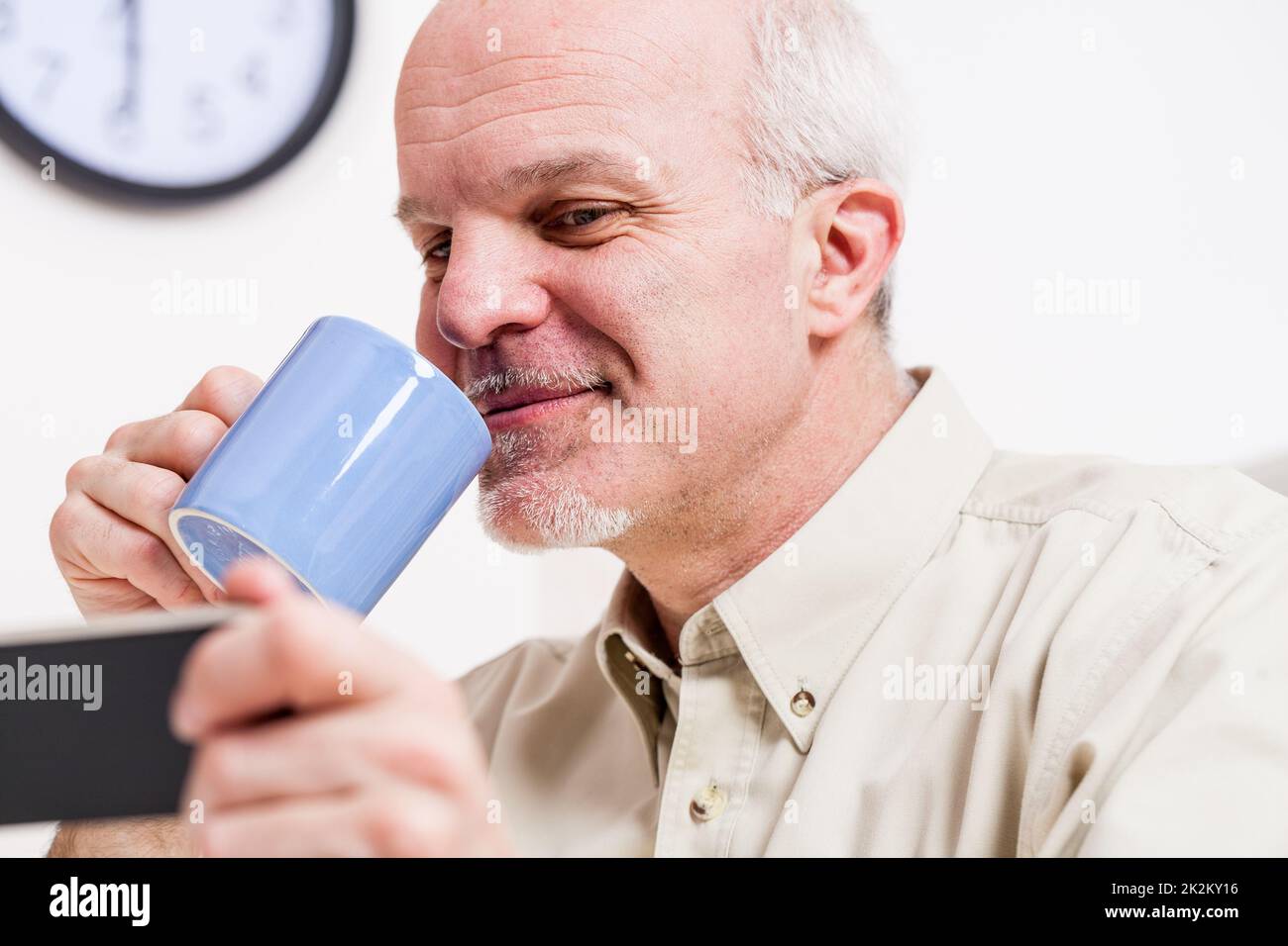 mature smiling man reading on his smartphone screen Stock Photo - Alamy