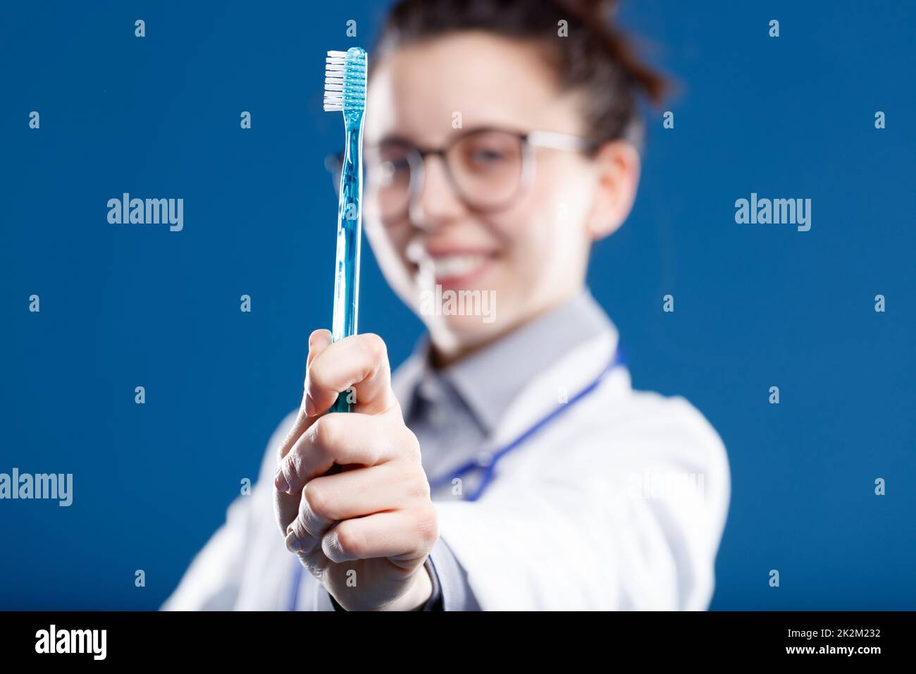 brush your teeth! smiling dentist shows toothbrush Stock Photo - Alamy