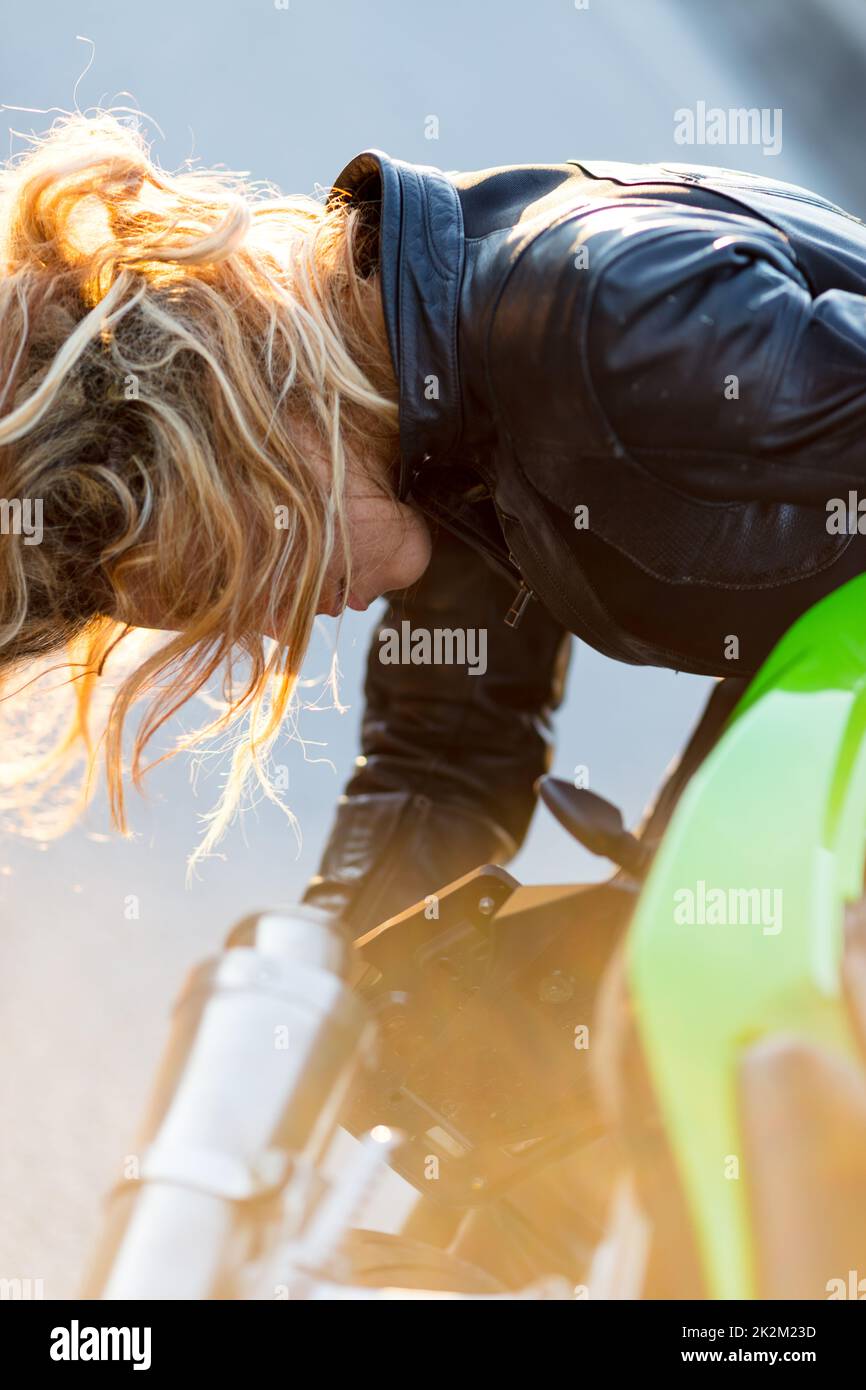 woman setting up her motorcycle to run Stock Photo - Alamy