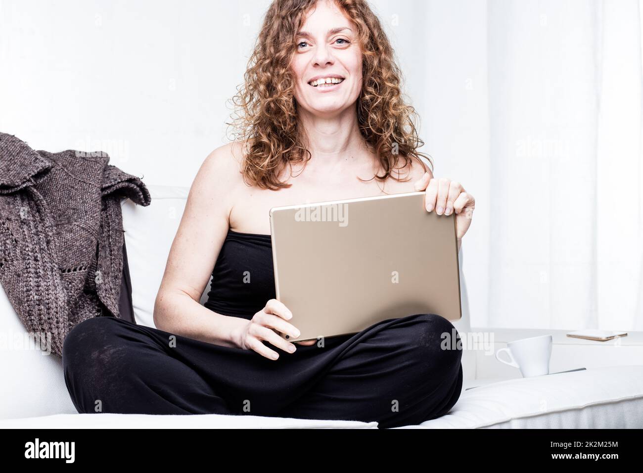 Happy pretty woman with computer and sweater Stock Photo - Alamy