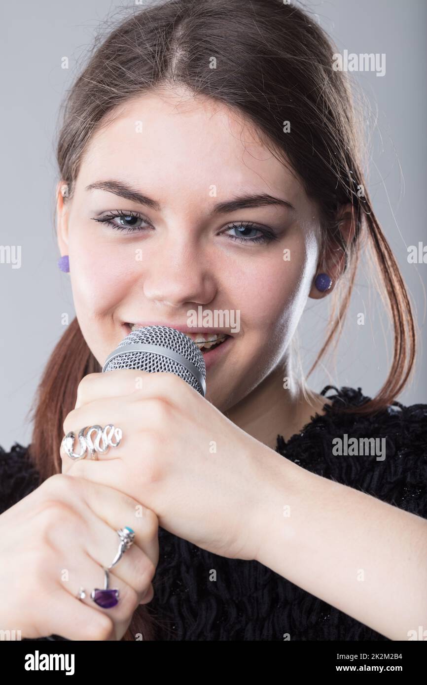 girl holding a microphone and singing Stock Photo - Alamy