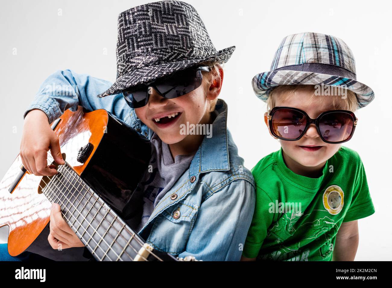 Two boys playing guitar and singing hi-res stock photography and images ...