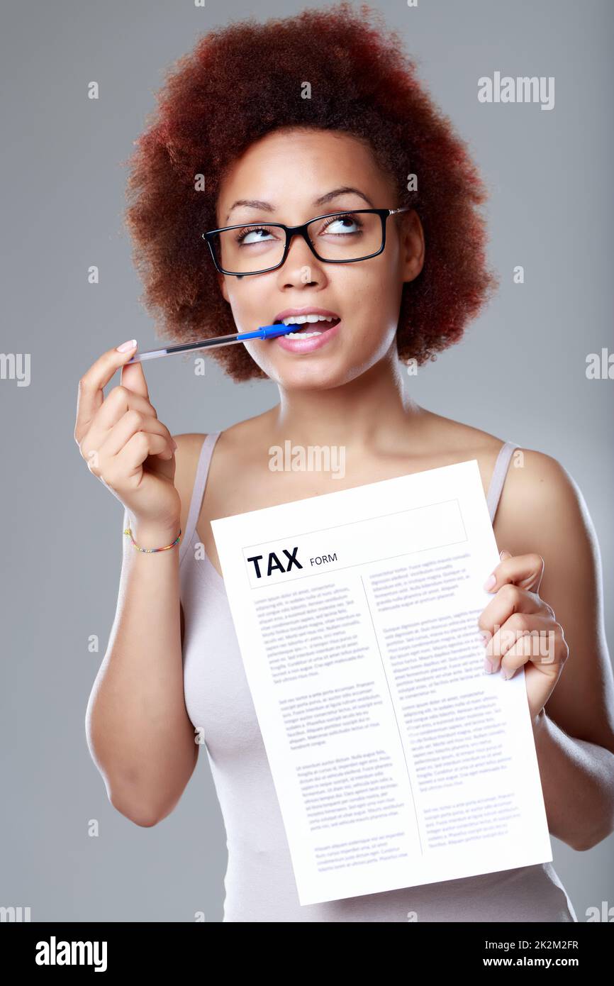 Pensive young Black woman holding a tax document Stock Photo - Alamy