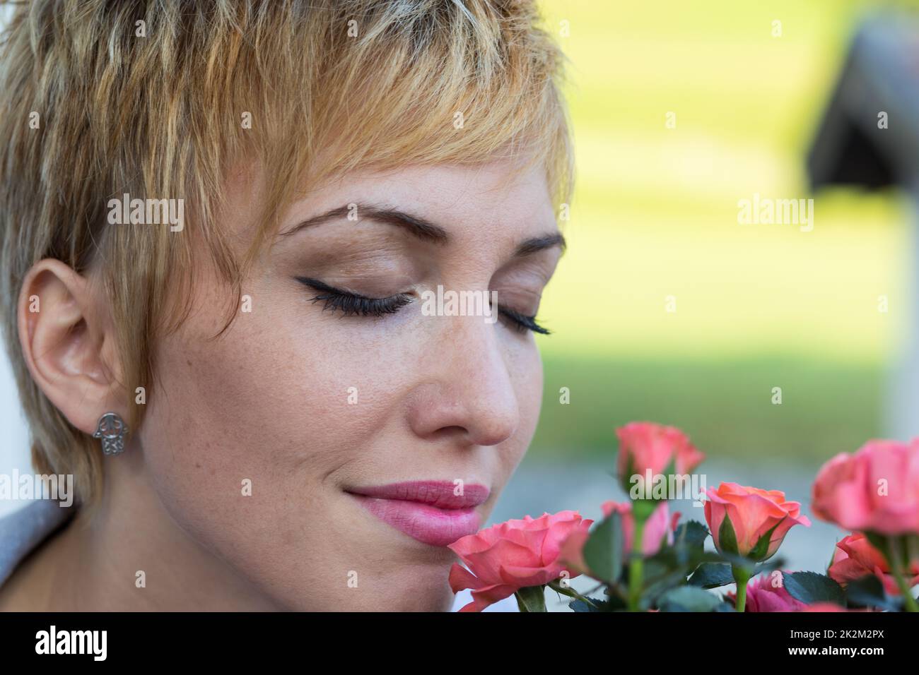 real woman smelling flowers outdoors Stock Photo - Alamy
