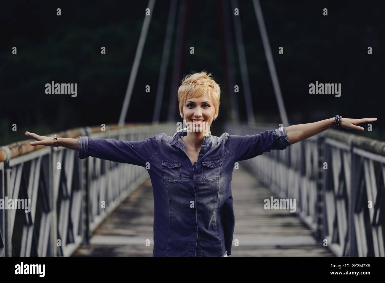 portrait of young woman on bridge and arms outstretched Stock Photo - Alamy