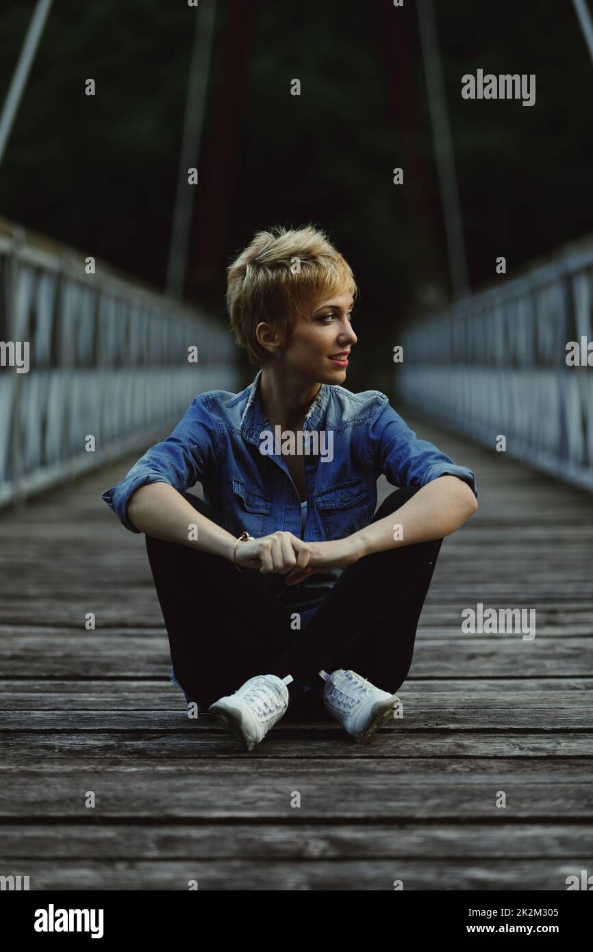 tourist sitting on bridge looks away Stock Photo - Alamy