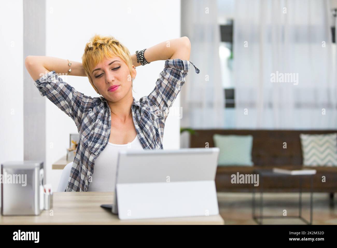 Thoughtful young woman pausing for a stretch Stock Photo - Alamy