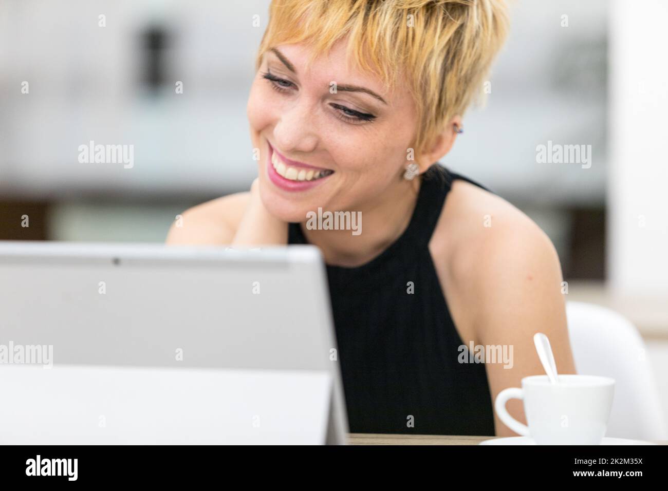 woman smiling to a computer screen Stock Photo - Alamy