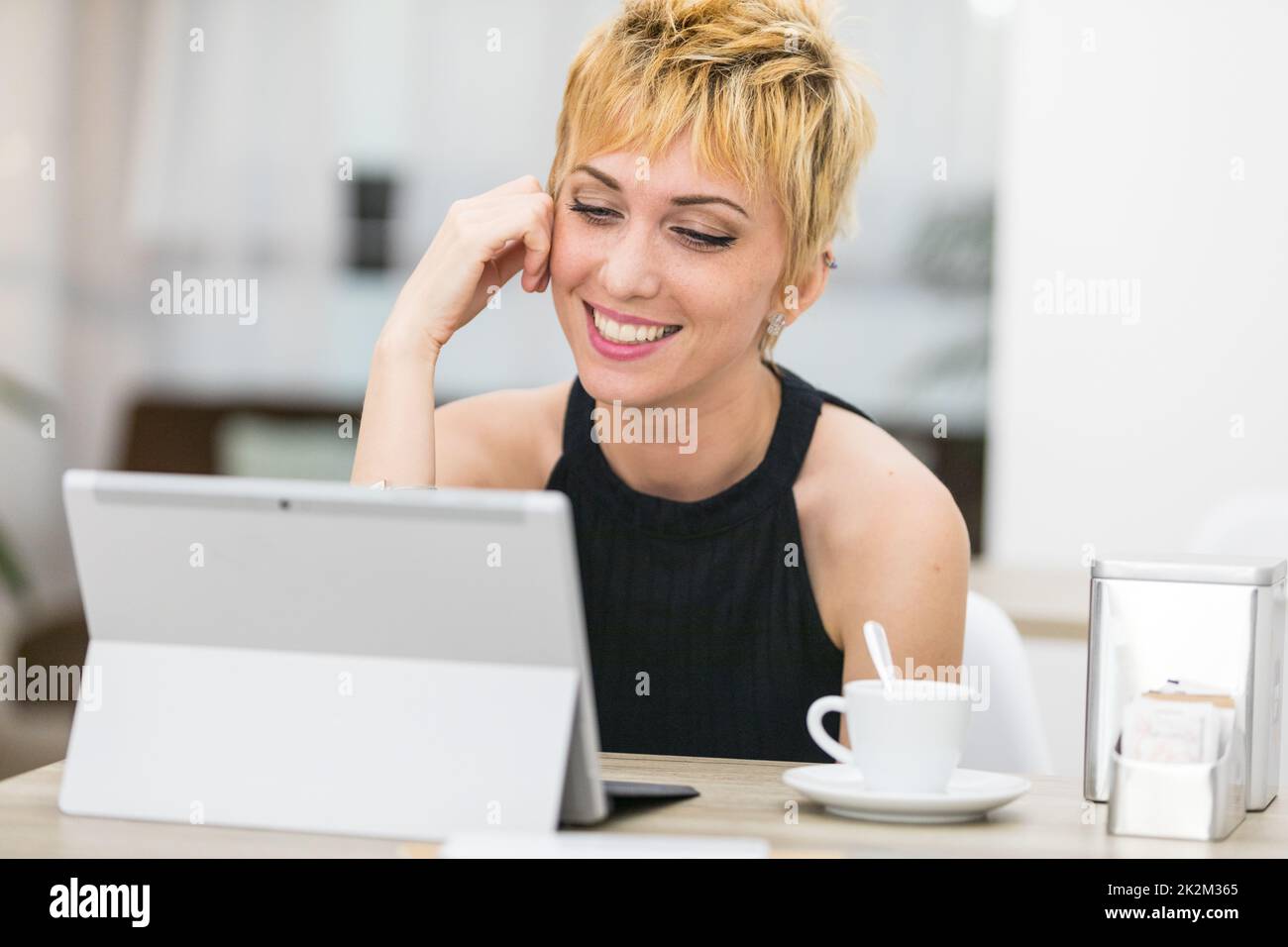 woman smiling to a computer screen Stock Photo - Alamy