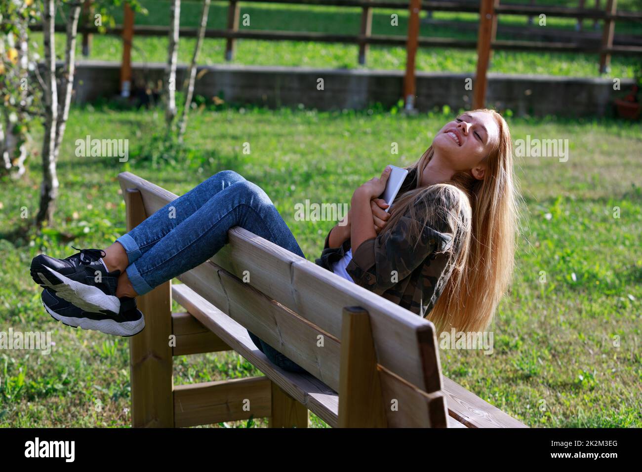 coy and sly smile of a girl hiding her tablet close to his heart Stock ...