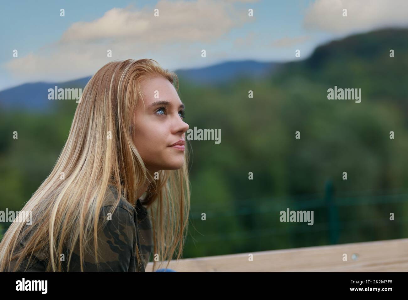 profile of a girl looking up, outdoors, with a nice blue sky for ...