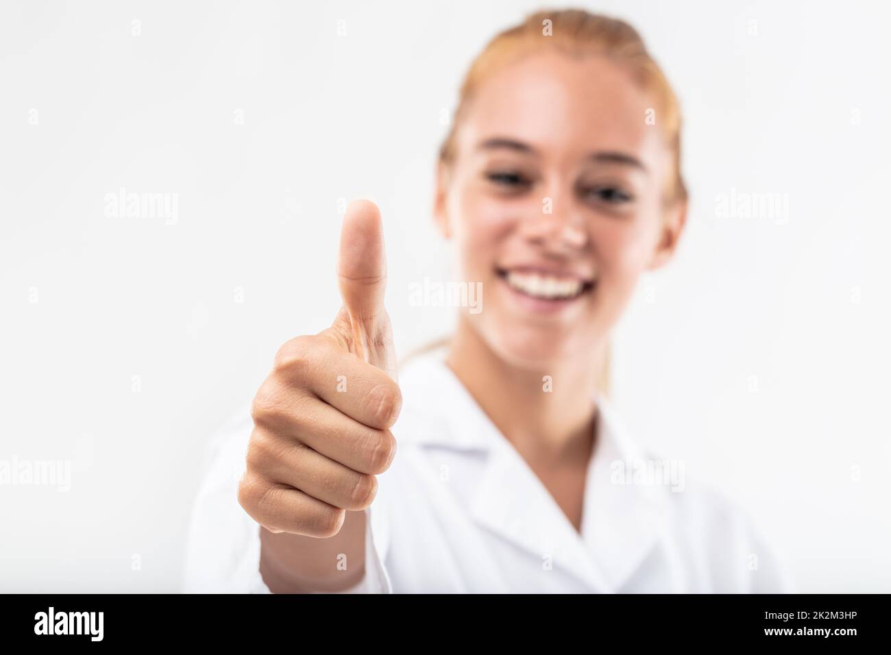 Happy young woman giving a thumbs up gesture Stock Photo - Alamy
