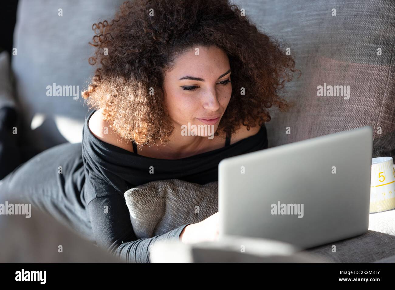 Beautiful woman with laptop on couch Stock Photo - Alamy