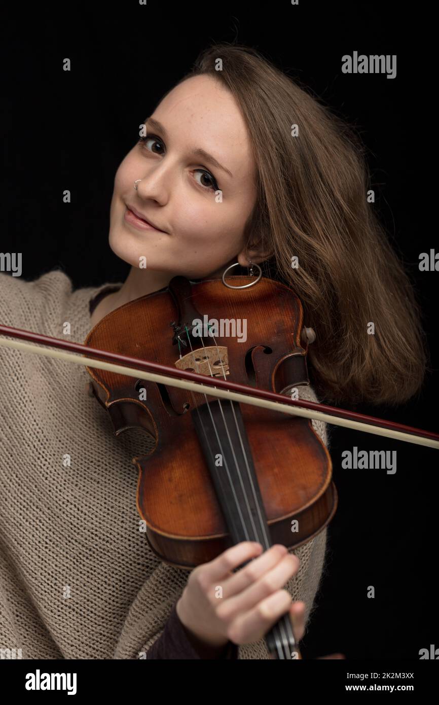 Attractive smiling woman violinist playing violin Stock Photo - Alamy