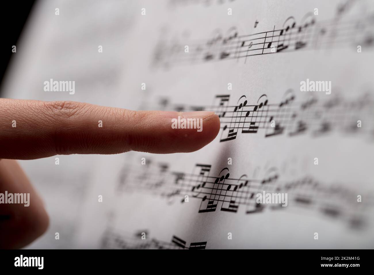 finger pointing to music score Stock Photo - Alamy