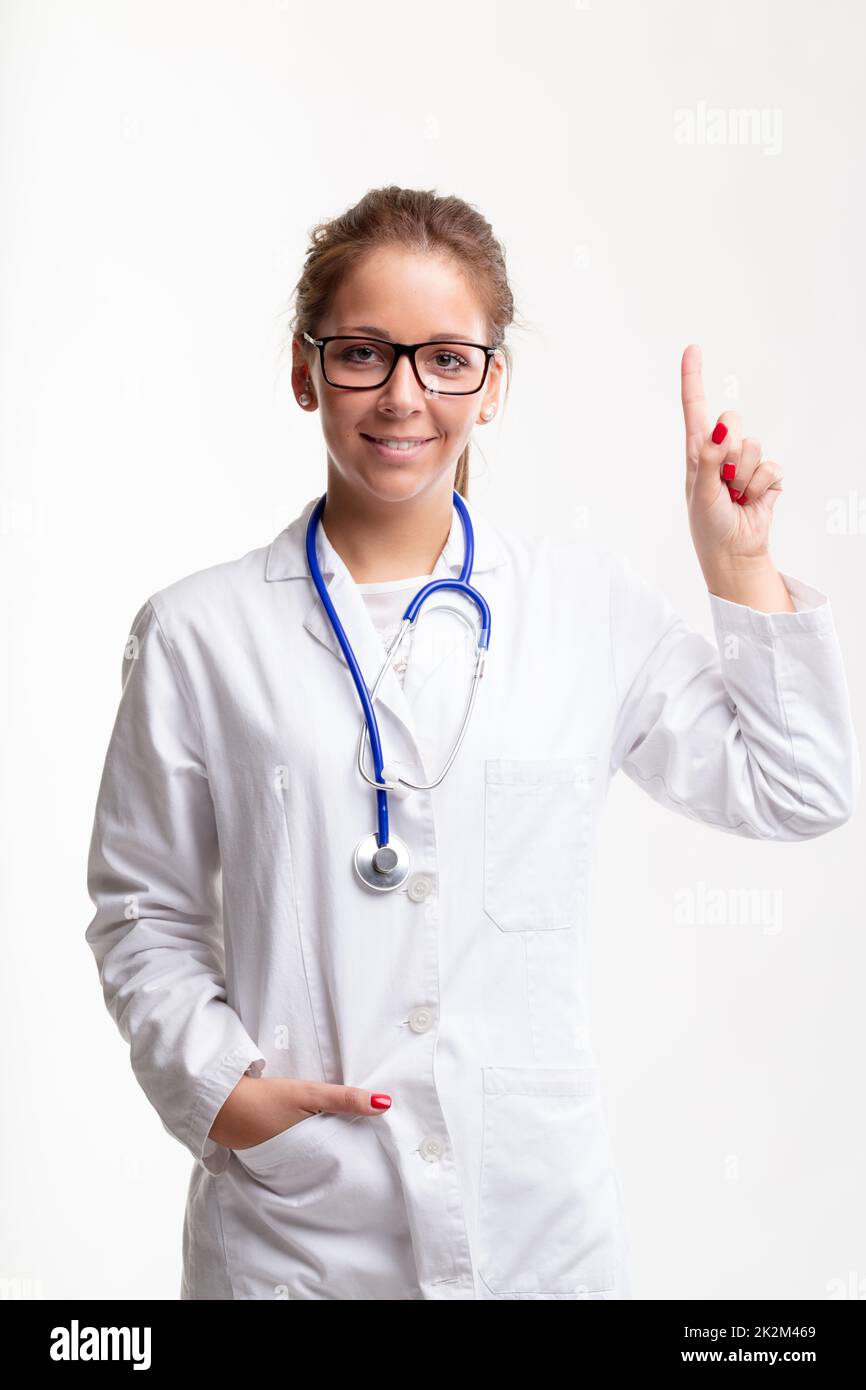 Relaxed smiling doctor pointing above her head Stock Photo - Alamy