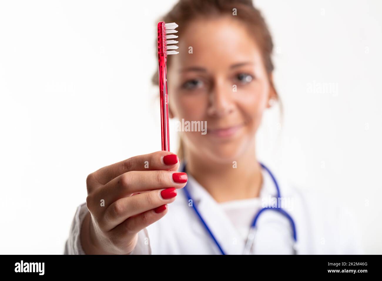 Dental nurse, dentist or hygienist holding up a red toothbrush Stock ...