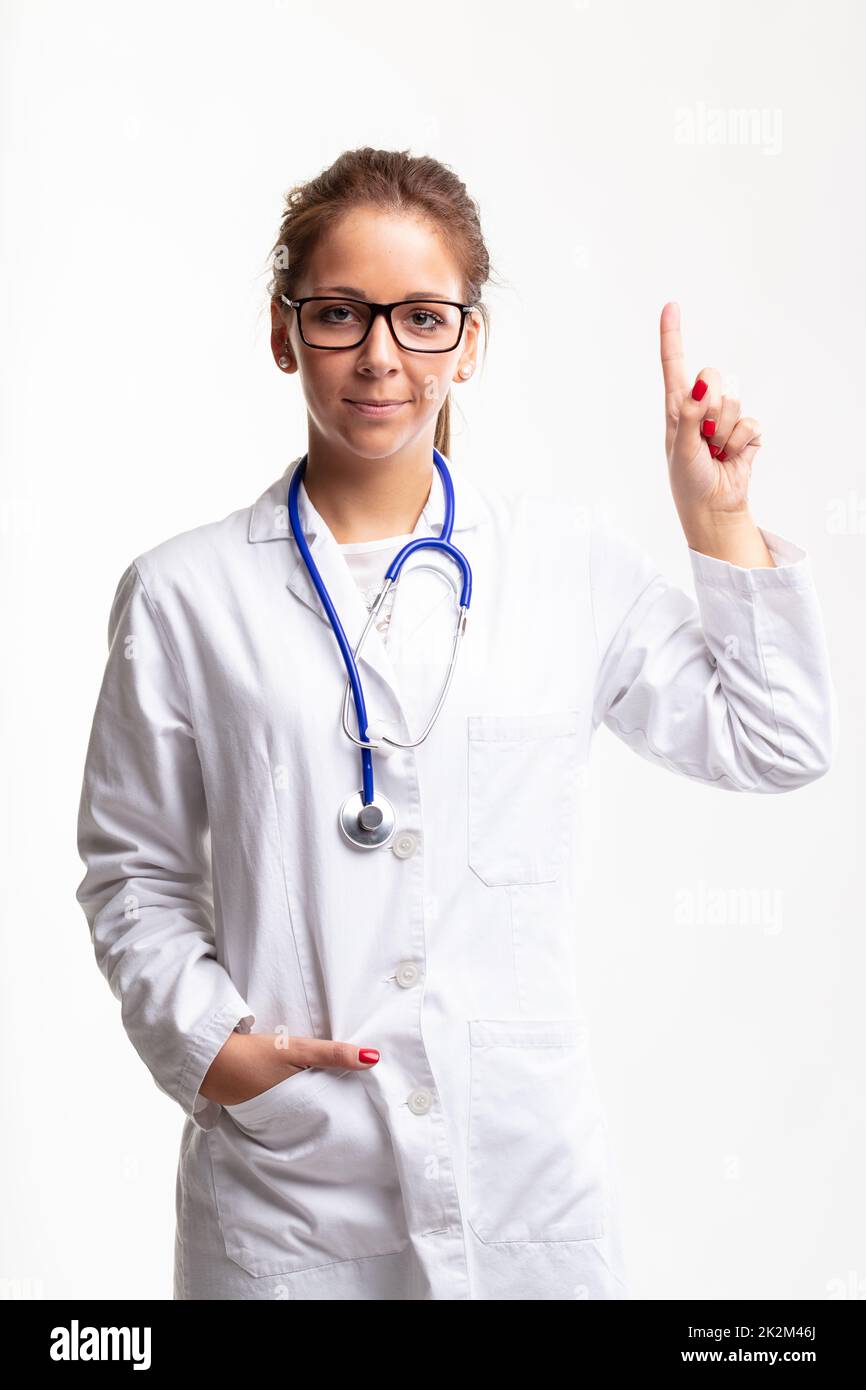 Relaxed young female doctor or nurse pointing up Stock Photo - Alamy