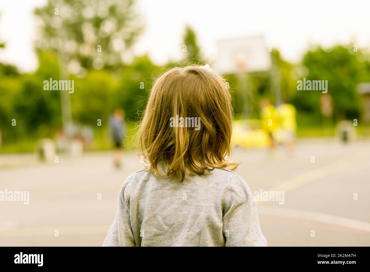 girl alone watching other play Stock Photo - Alamy