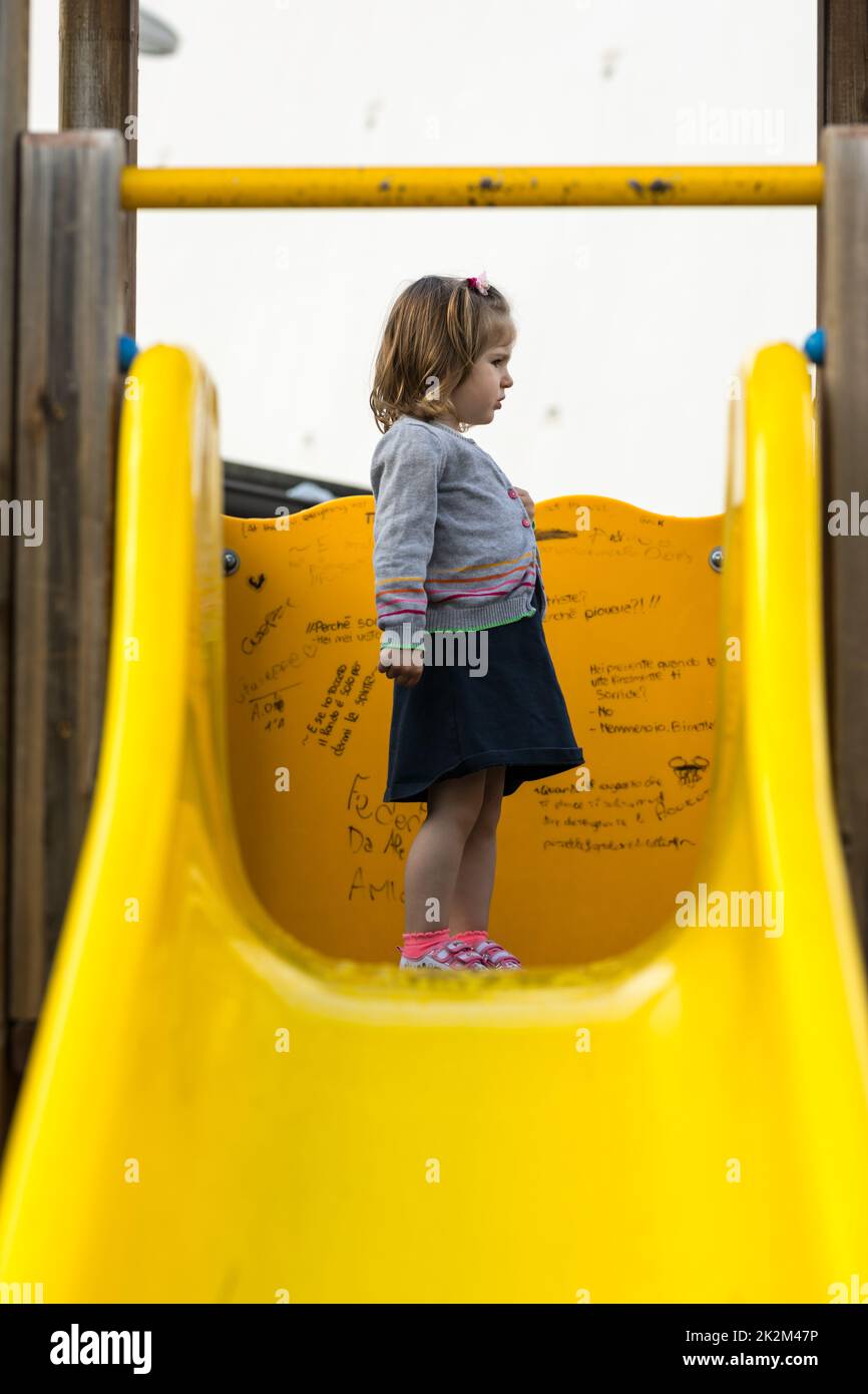 little girl on a slide watching something Stock Photo - Alamy