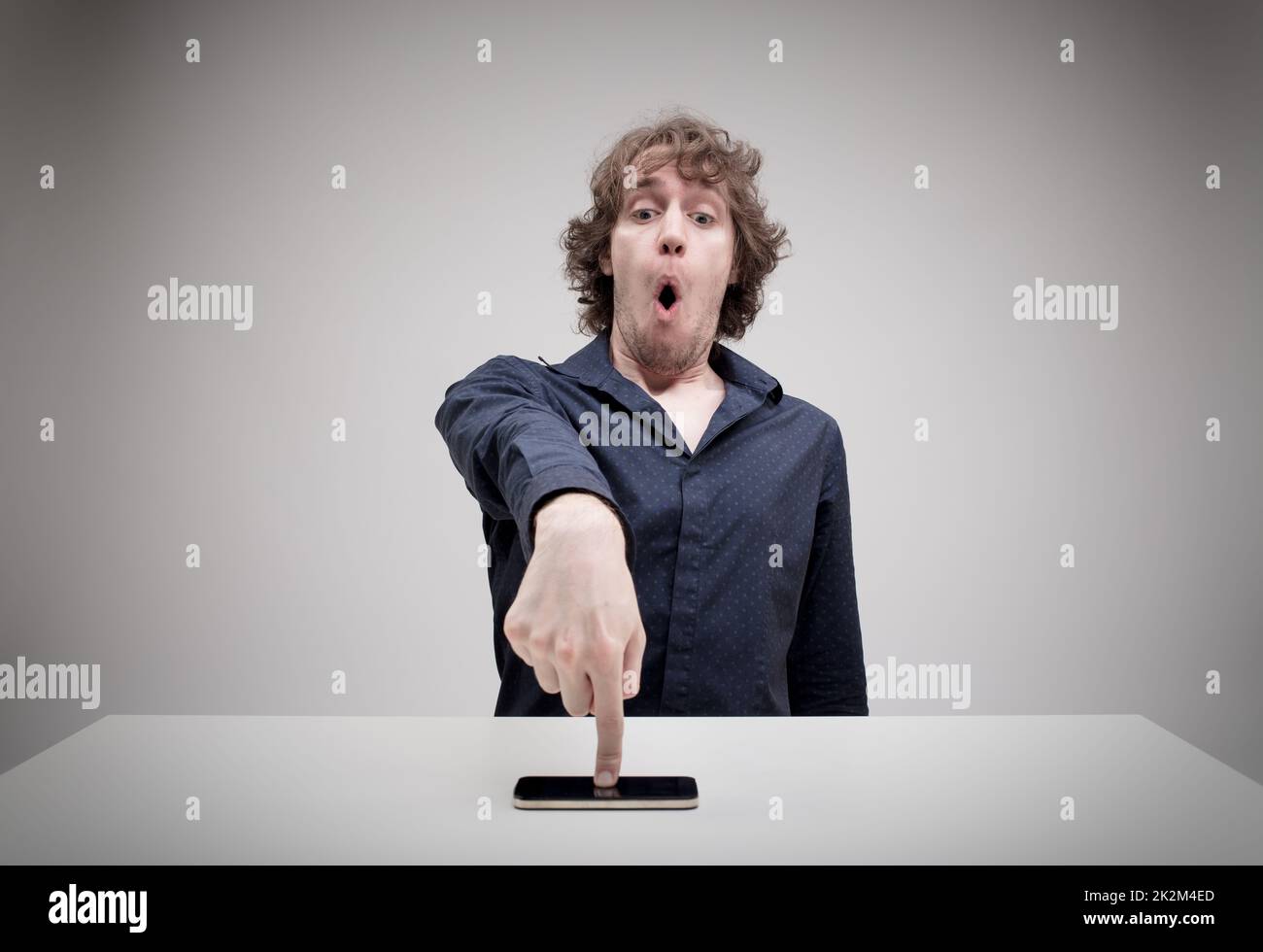 surprised man touching his smartphone screen Stock Photo - Alamy