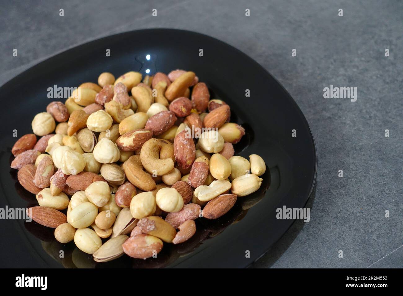 There is a plateful of nuts, hazelnuts, peanuts, cashews in the plate ...