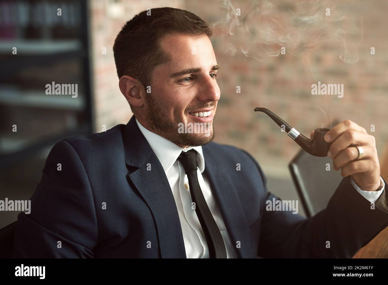 Suave And Successful Shot Of A Stylish Businessman Smoking A Pipe In