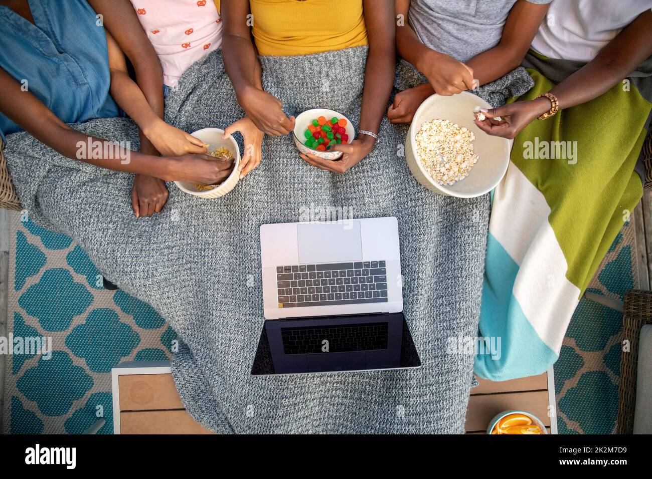 Overhead view of family enjoying snacks in front of laptop Stock Photo ...