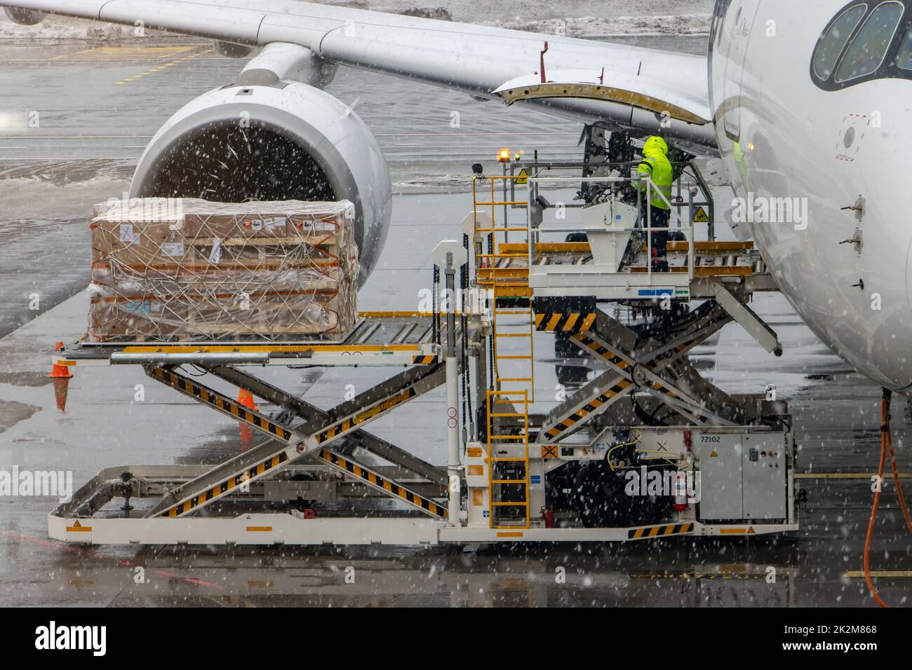 Loading a plane before take off at a airport when snowing Stock Photo ...