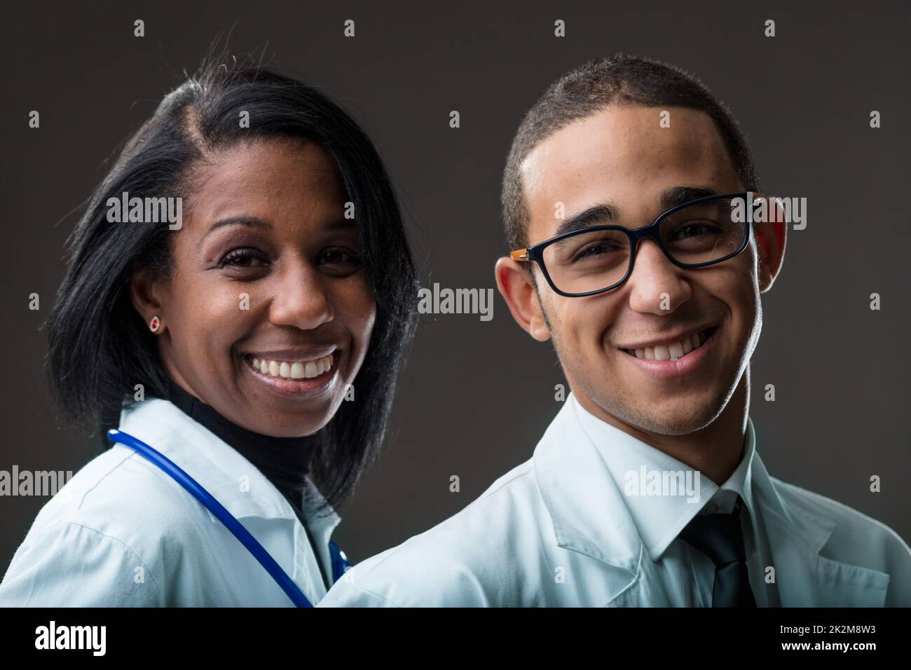 couple of afro-american doctors on dark background Stock Photo - Alamy